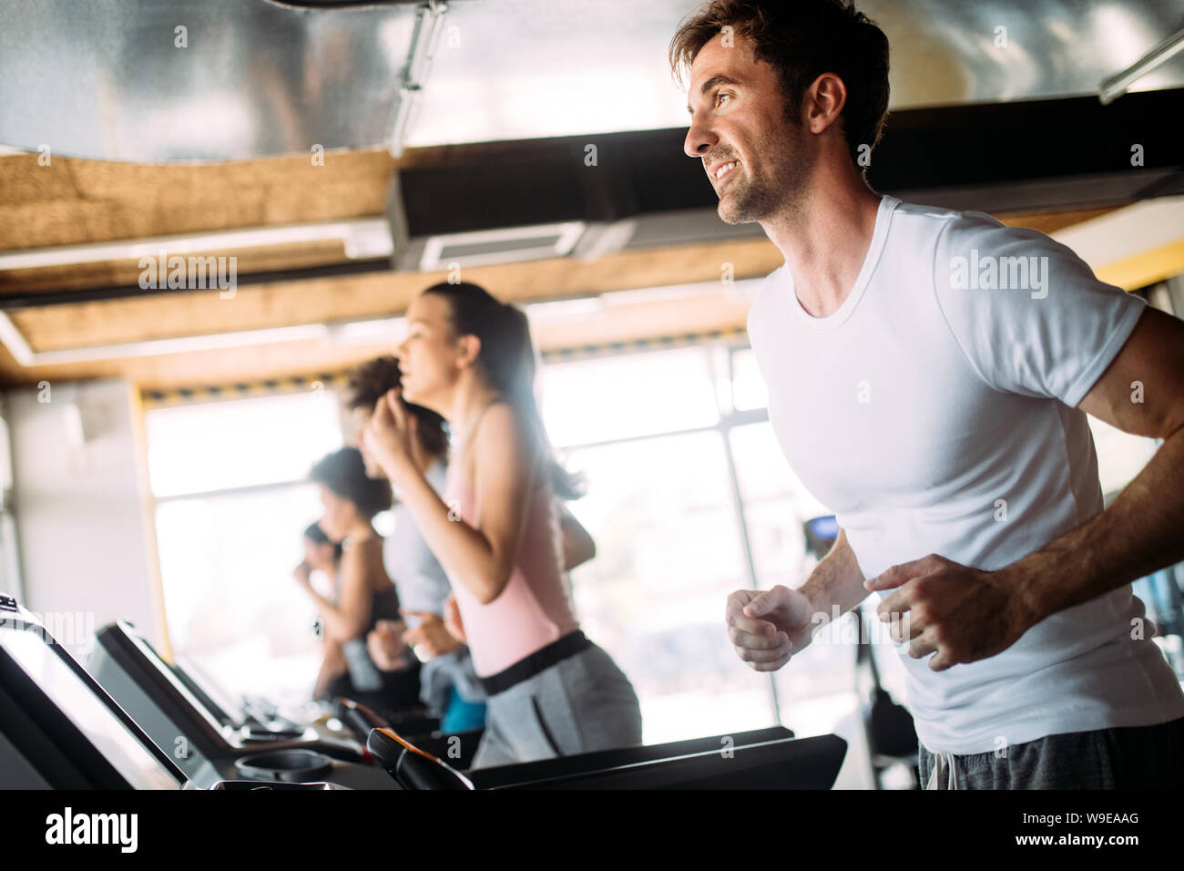 Beautiful fit people exercising together in gym Stock Photo - Alamy