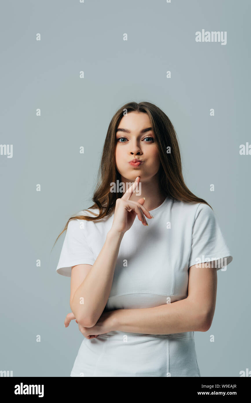 beautiful funny girl blowing cheeks isolated on grey Stock Photo - Alamy