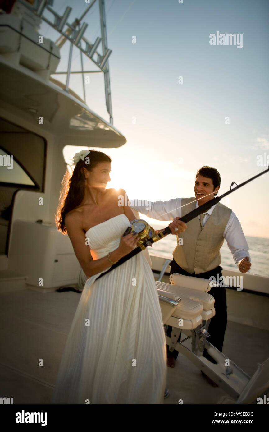 Happy newlyweds fishing from a boat Stock Photo - Alamy