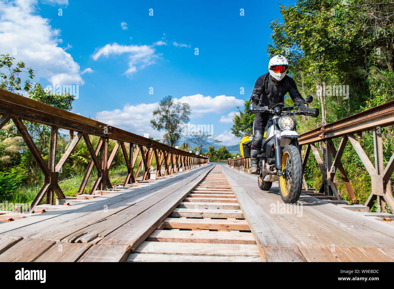 Man driving his scrambler type motorcycle over temporary bridge Stock ...
