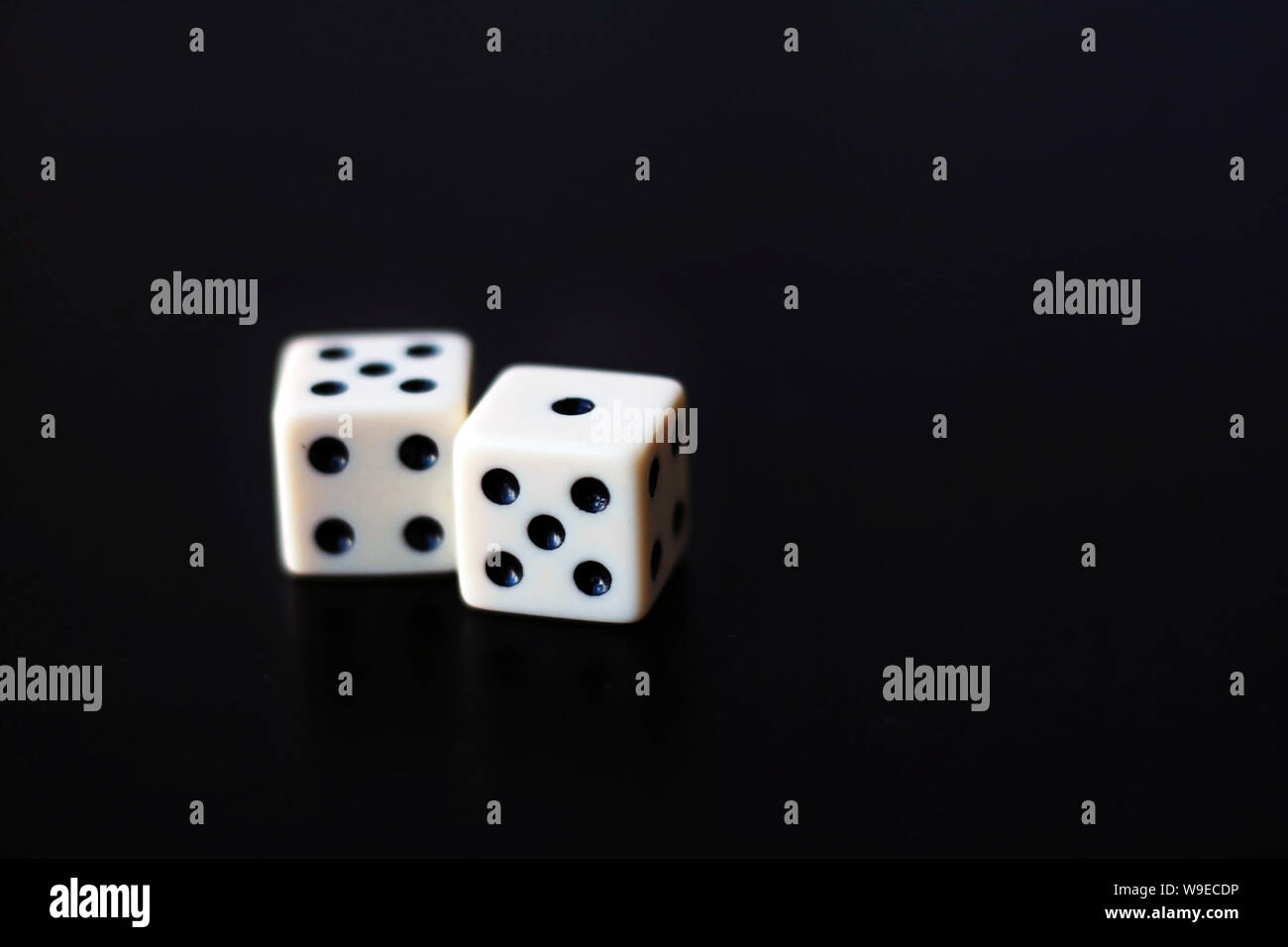 Two white dice on a black background Stock Photo - Alamy