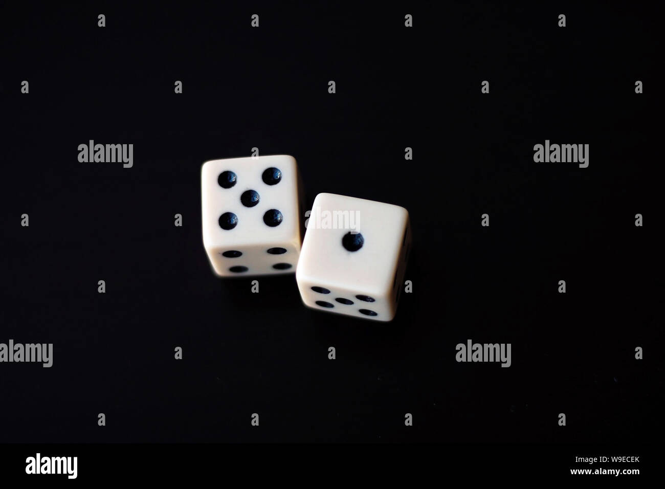 Two white dice on a black background Stock Photo - Alamy