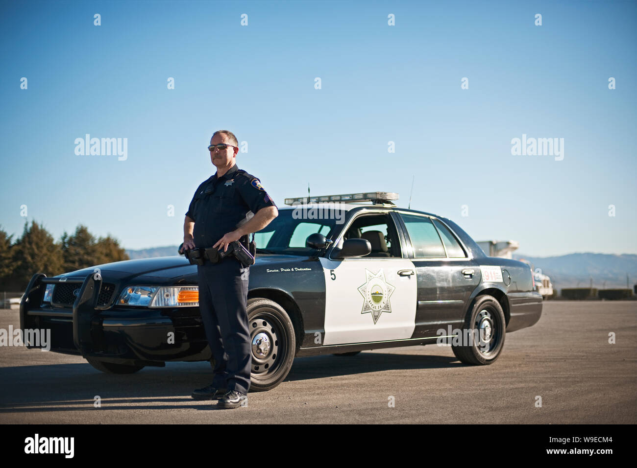 Portrait of policeman in front of his police car Stock Photo - Alamy