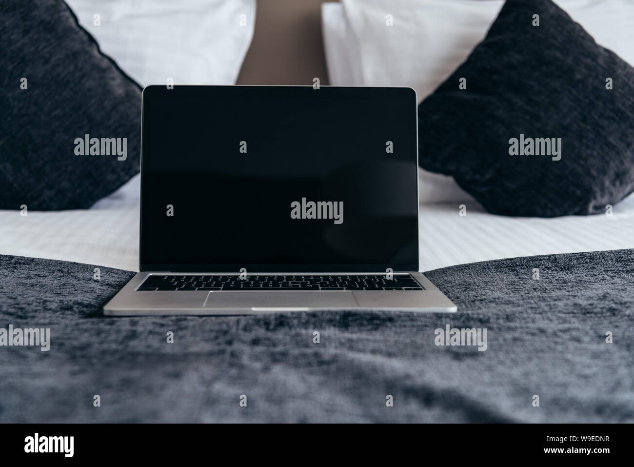 laptop with blank screen on bed in hotel room Stock Photo - Alamy