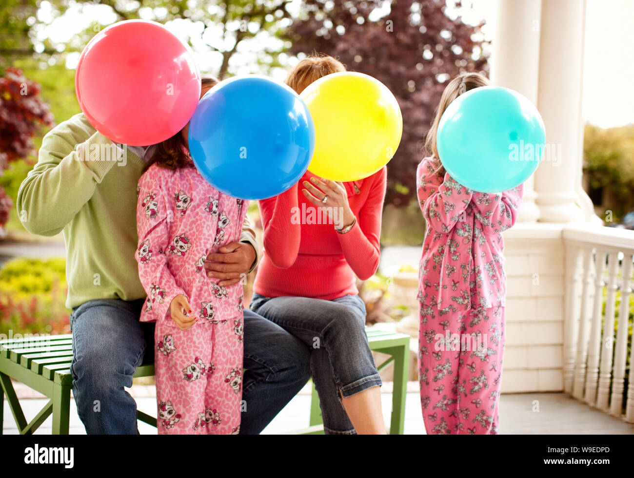 Humorous view of family blowing up balloons Stock Photo - Alamy
