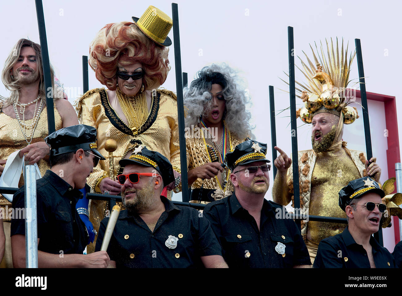 Brighton, 2019. Transvestites in glam costumes and men dressed as NYPD ...