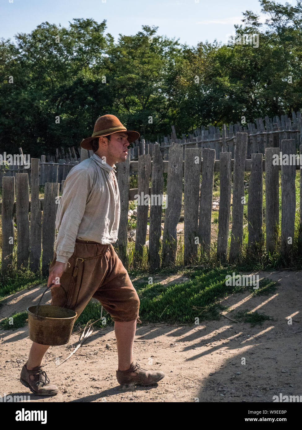 Pilgrim man walking with pail Stock Photo - Alamy