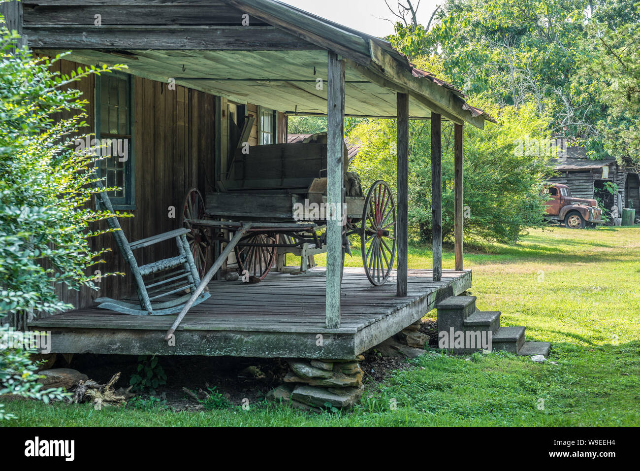 Rustic old homestead with a wooden wagon and other farm equipment left ...