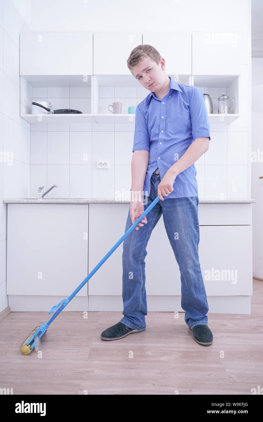 Teenager Boy Mopping The Floor and helps his parents to clean on ...
