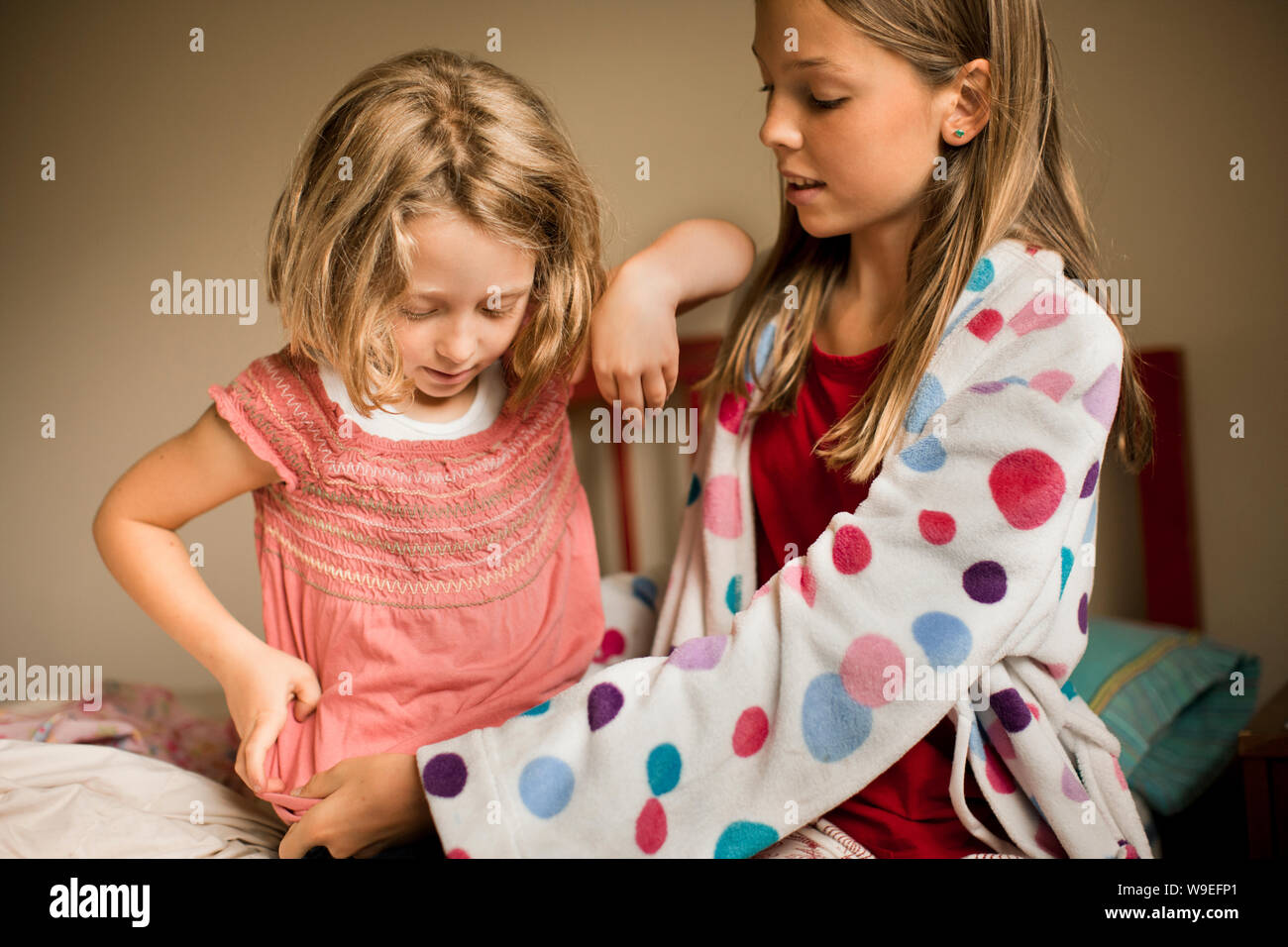Big sister helping her little sister get dressed in the morning Stock ...