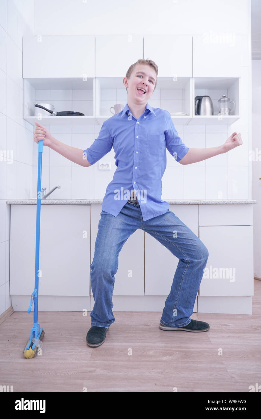 Teenager Boy Mopping The Floor and helps his parents to clean on ...