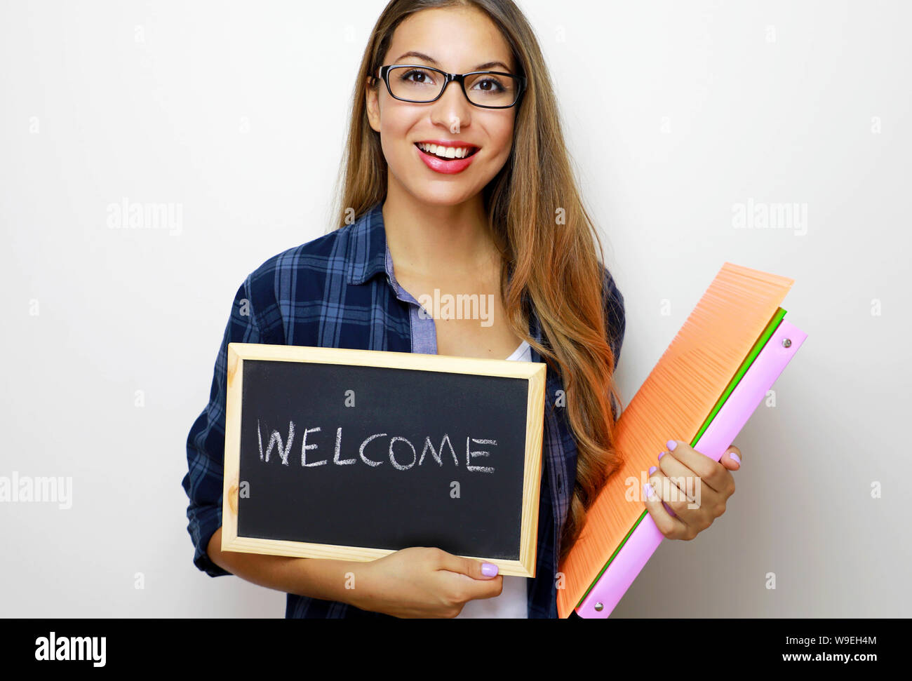 Young female teacher holding folders and blackboard with written ...