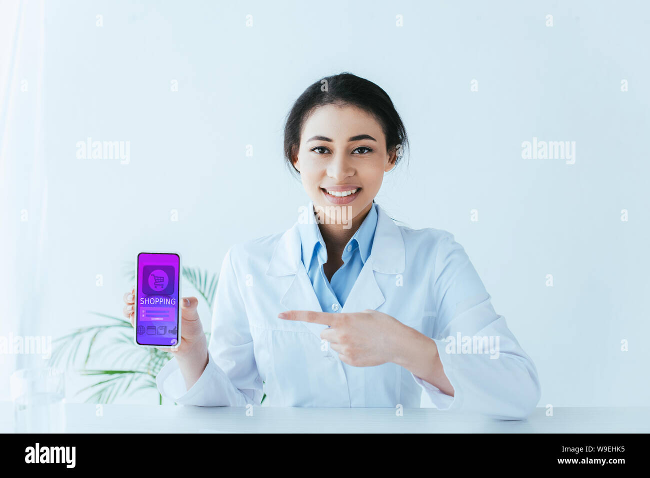 beautiful latin doctor showing smartphone with online shopping app on ...