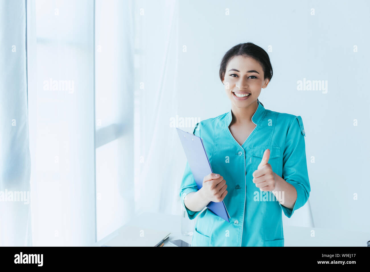 happy latin doctor showing thumb up and smiling at camera while ...