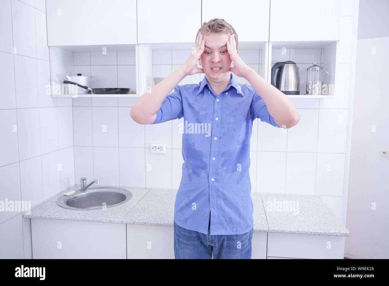 nice boy in blue shirt with emotions on kitchen alone Stock Photo - Alamy