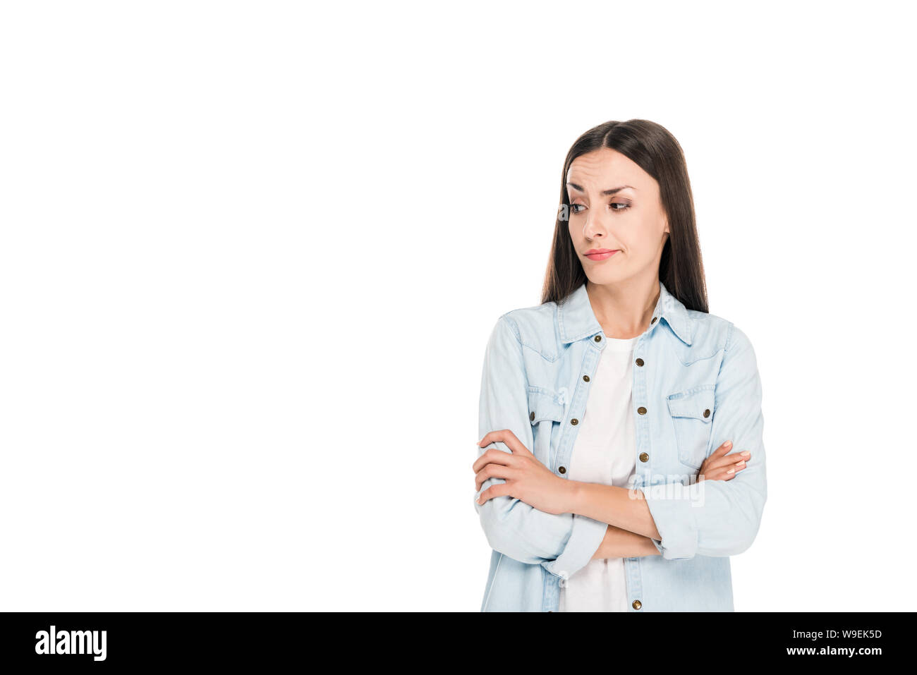 skeptical brunette woman standing with crossed arms isolated on white ...