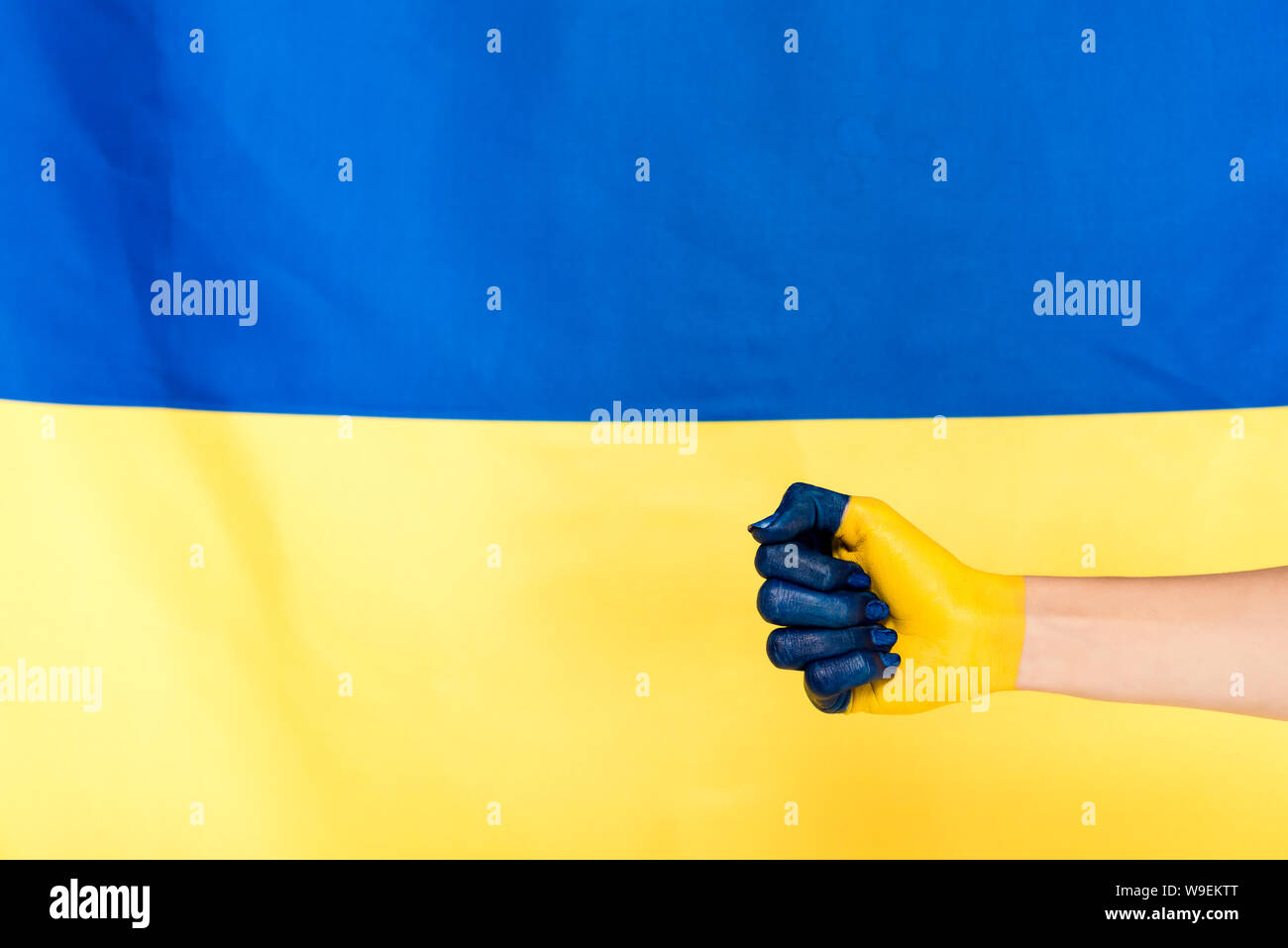 partial view of painted hand on Ukrainian flag background Stock Photo ...