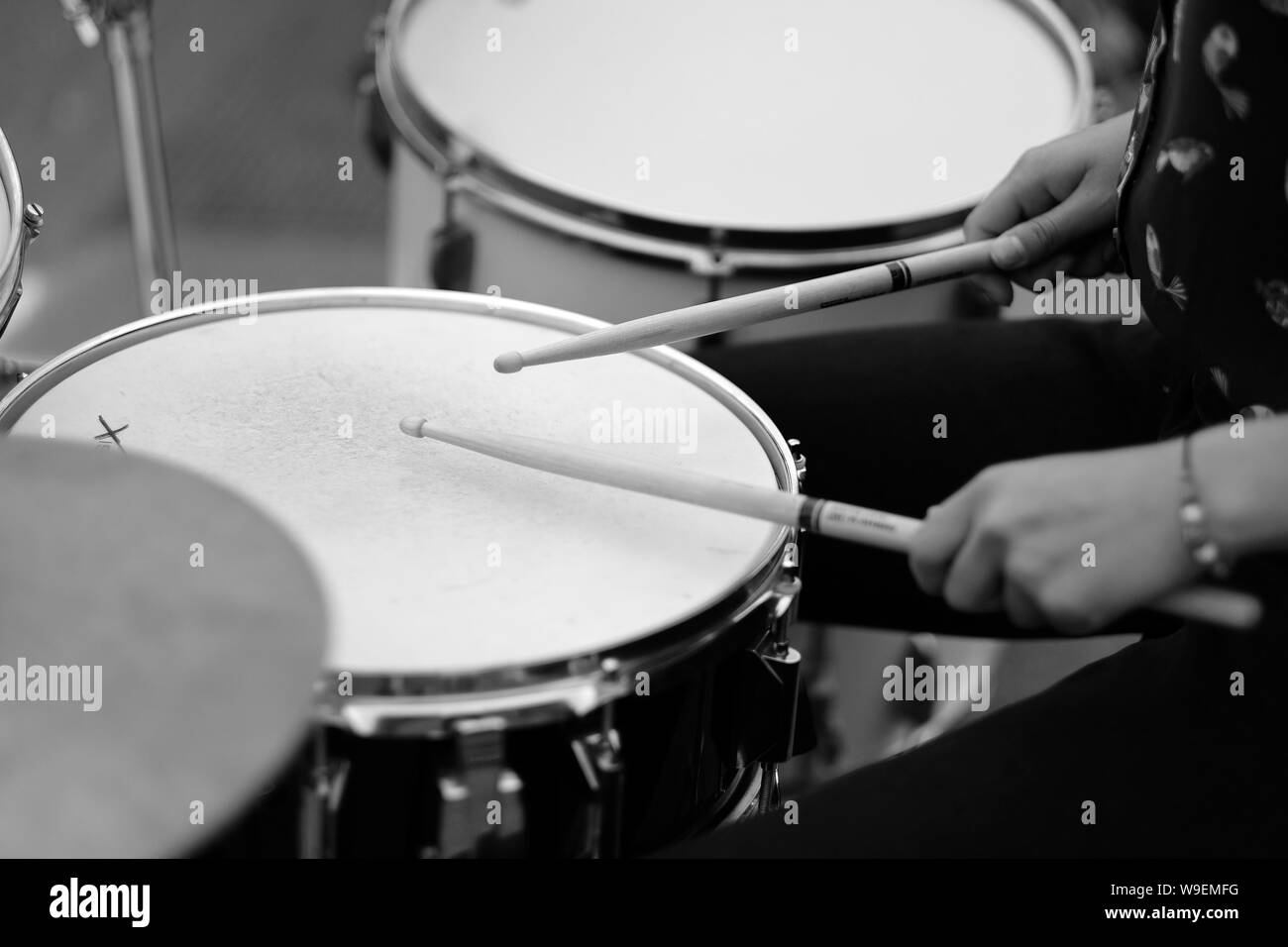The drummer's hands with chopsticks behind the drum set Stock Photo - Alamy