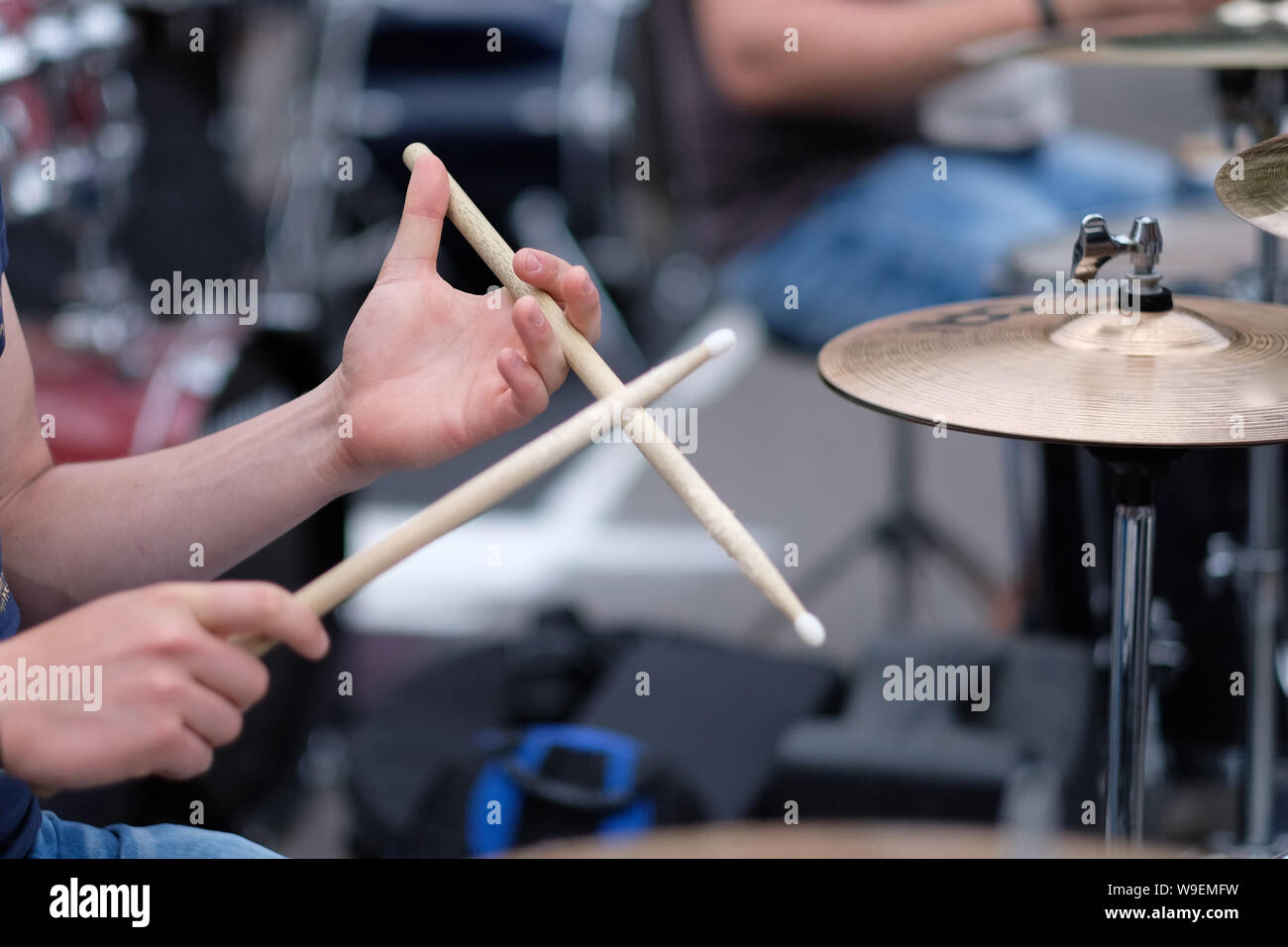 The drummer's hands with chopsticks behind the drum set Stock Photo - Alamy