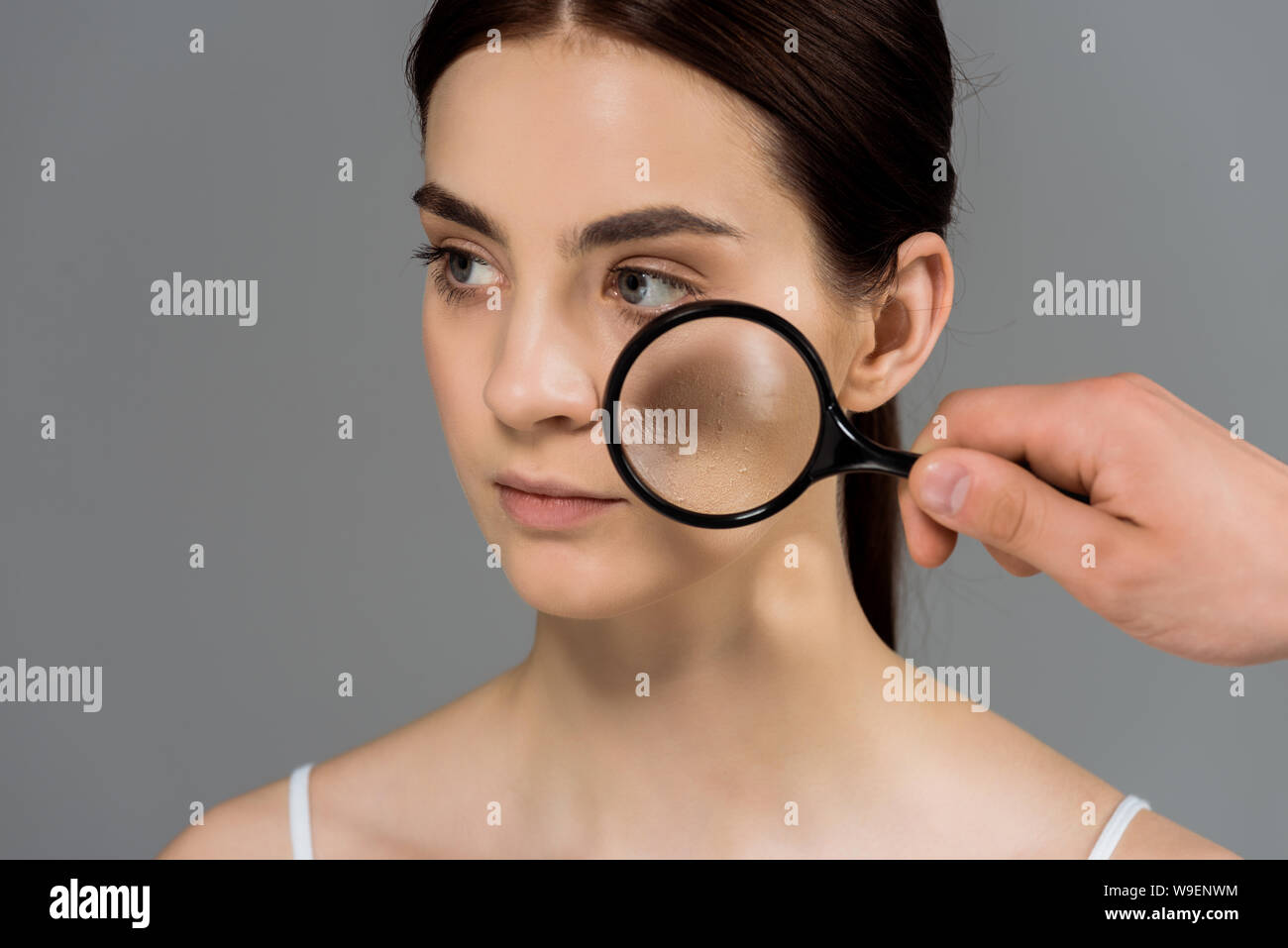 cropped view of man holding magnifier glass near woman with problem ...