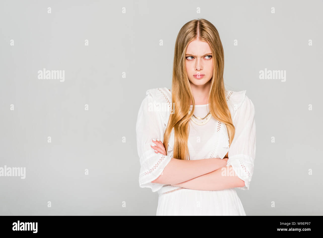 angry girl with crossed arms isolated on grey Stock Photo - Alamy