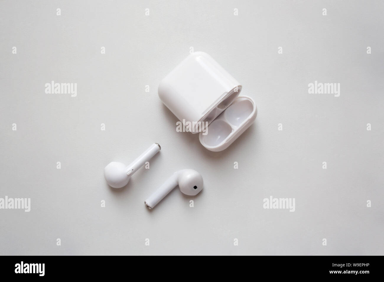 Glossy white wireless earbuds with plastic container isolated on white ...