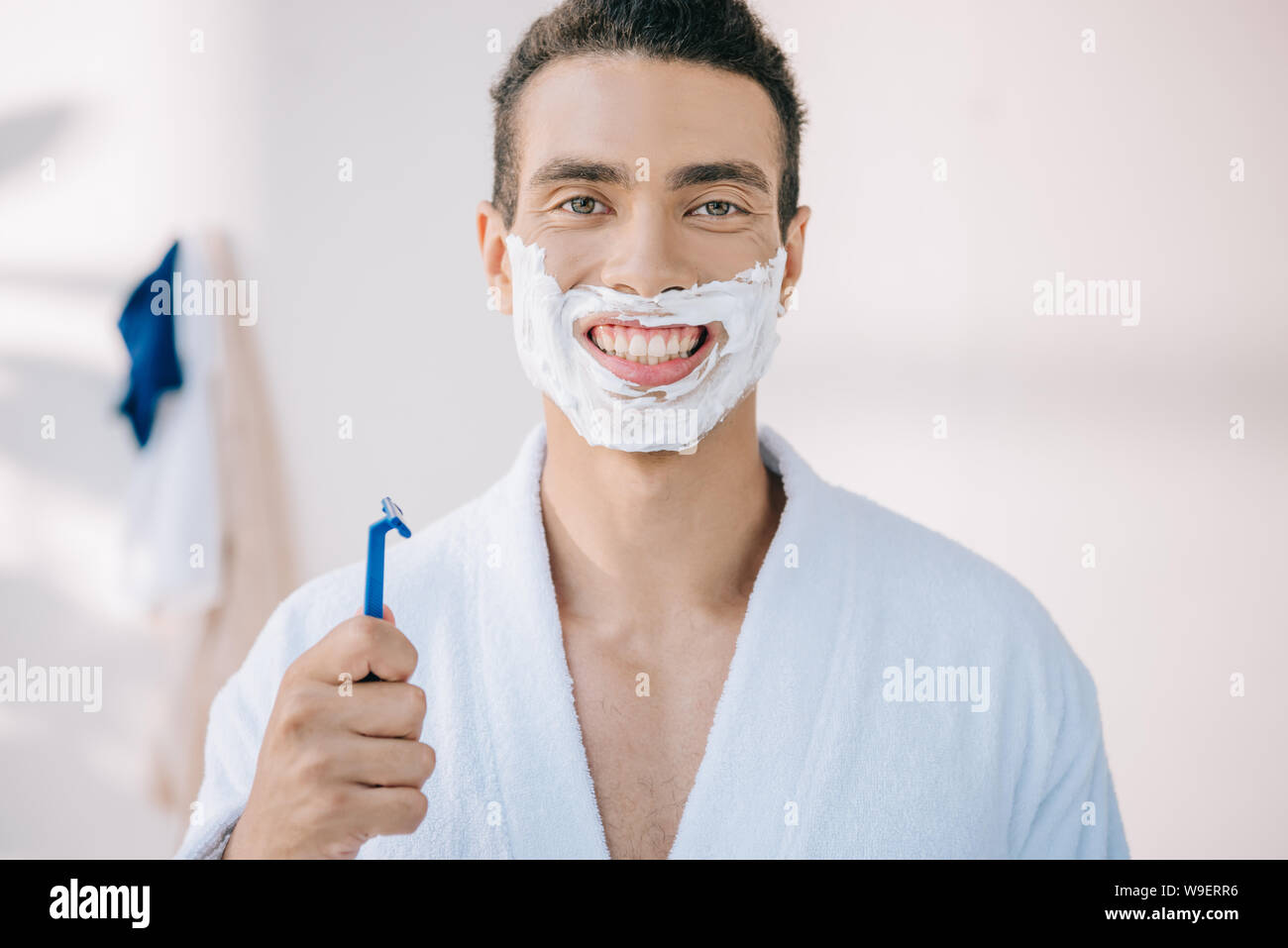 handsome man with shaving cream on face holding razor and looking at camera Stock Photo - Alamy