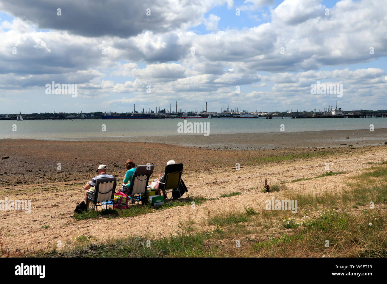 People on the beach at Hamble-Le-Rice looking towards Fawley oil ...