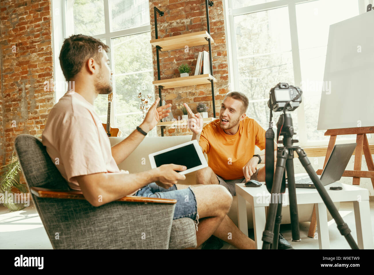 Two young caucasian male bloggers in casual clothes with professional ...