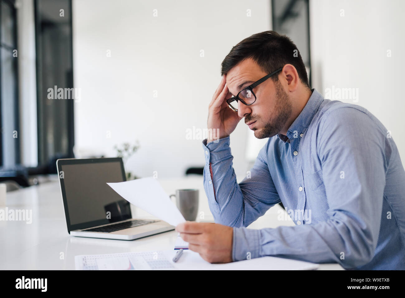 Stressed out and worried overworked businessman in office working under ...