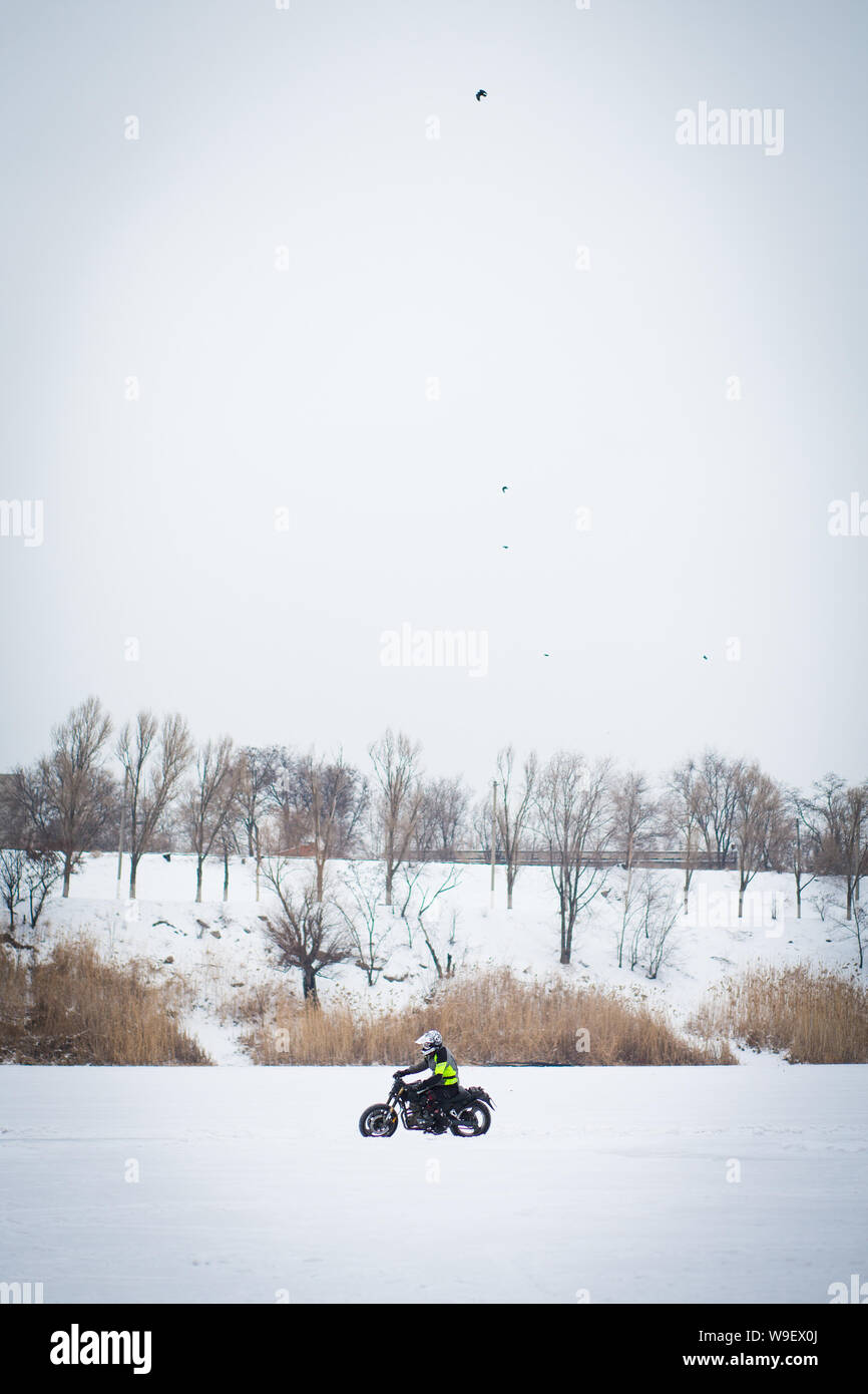 A guy rides a motorcycle on a frozen lake Stock Photo - Alamy