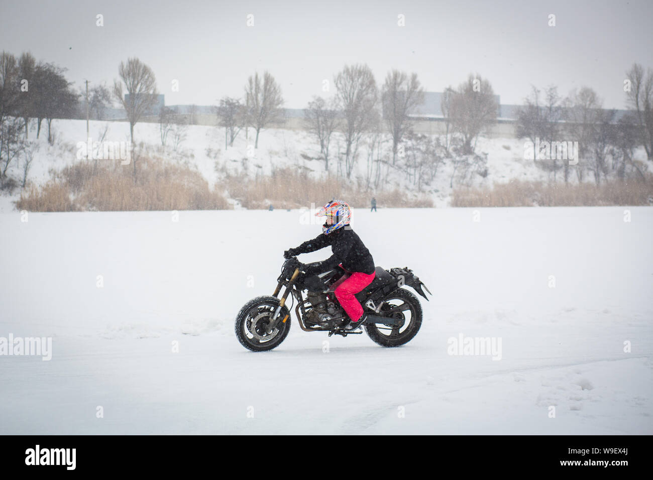 A girl rides a motorcycle on a frozen lake Stock Photo - Alamy