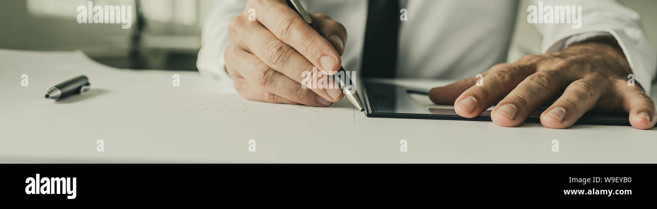 Wide view image of an architect working on a project drawing using a ...