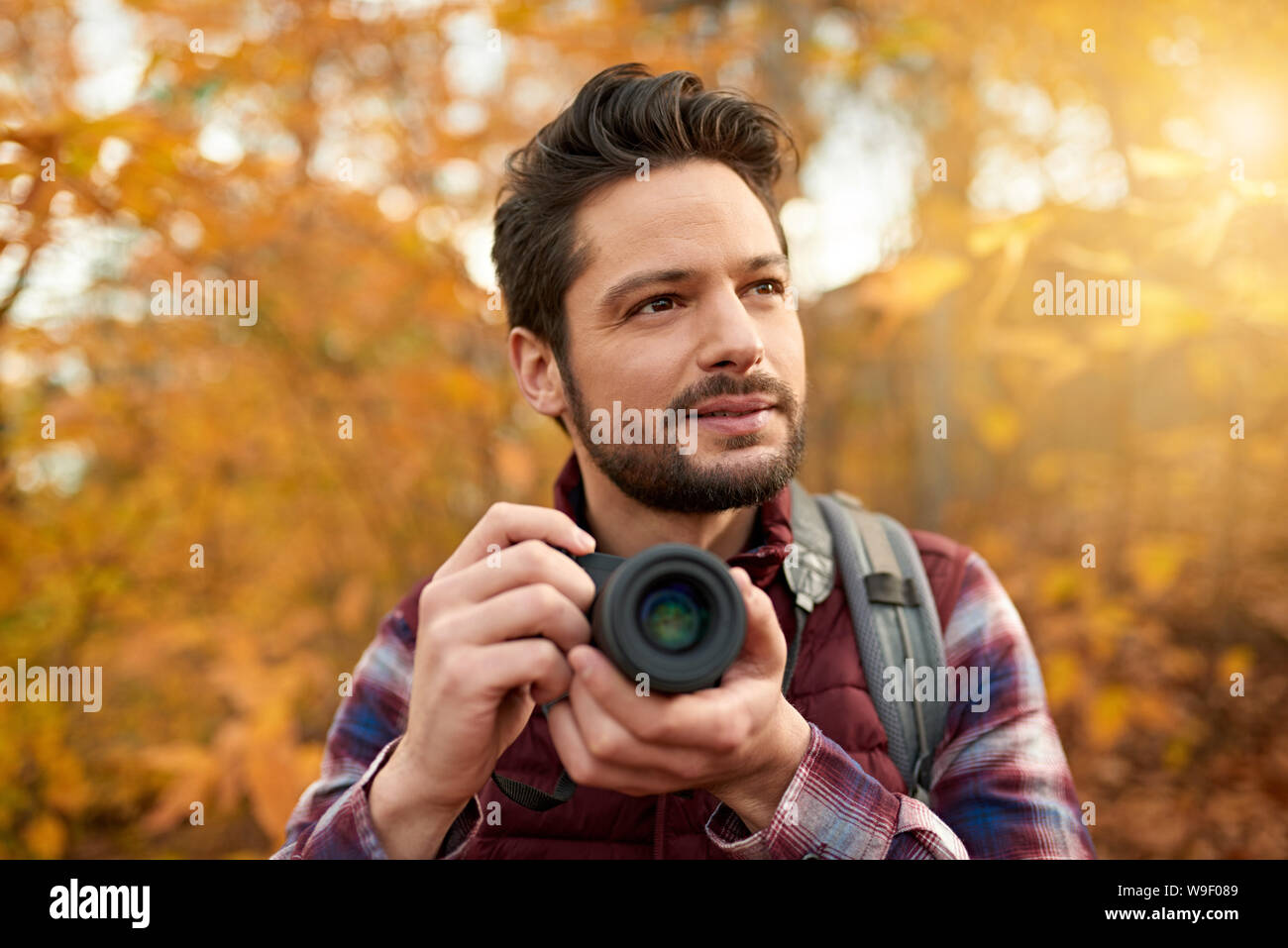 Attractive caucasian man taking pictures with a mirrorless camera ...