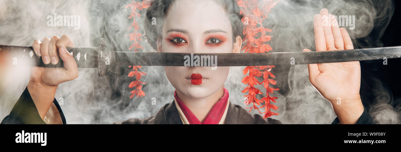 selective focus of beautiful geisha in black kimono holding katana in ...