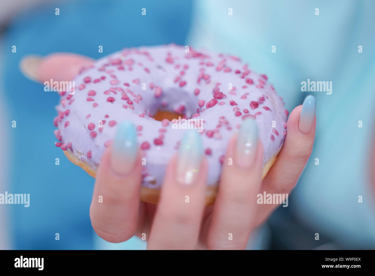 Hungry attractive girl eating donut on the kitchen Stock Photo - Alamy