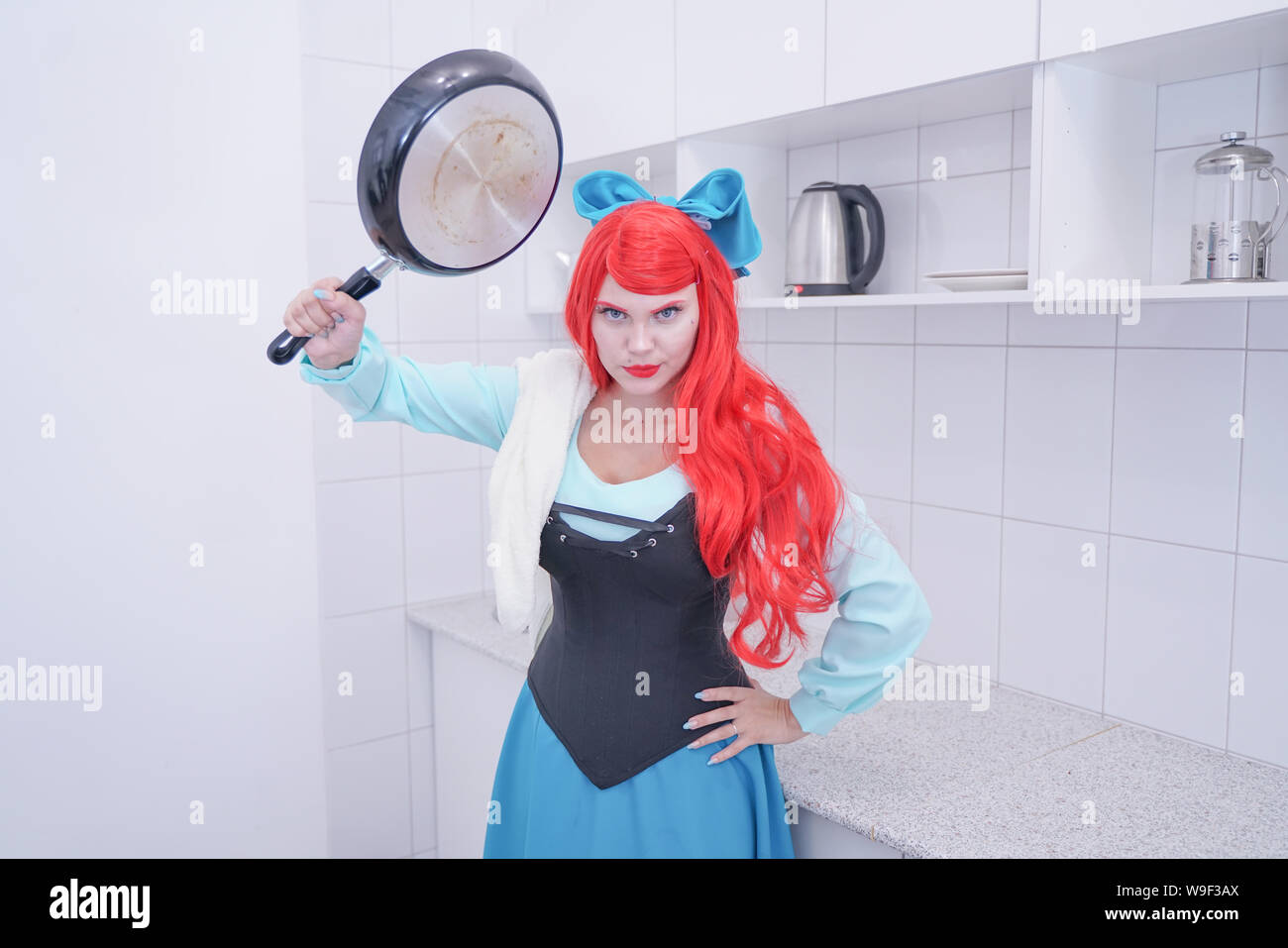 Redhaired plus size angry sad woman holding frying pan Stock Photo - Alamy