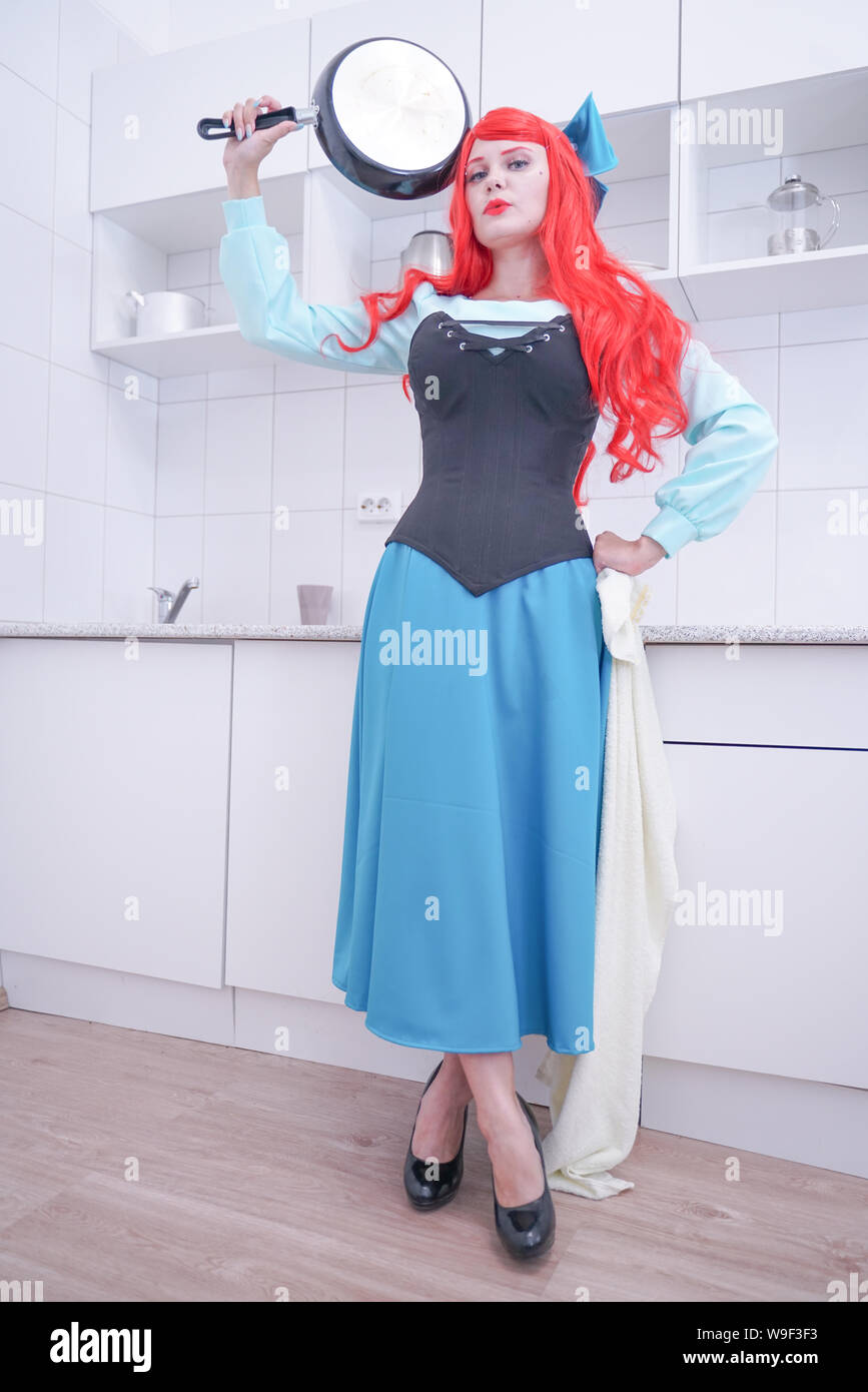 Redhaired plus size angry sad woman holding frying pan Stock Photo - Alamy