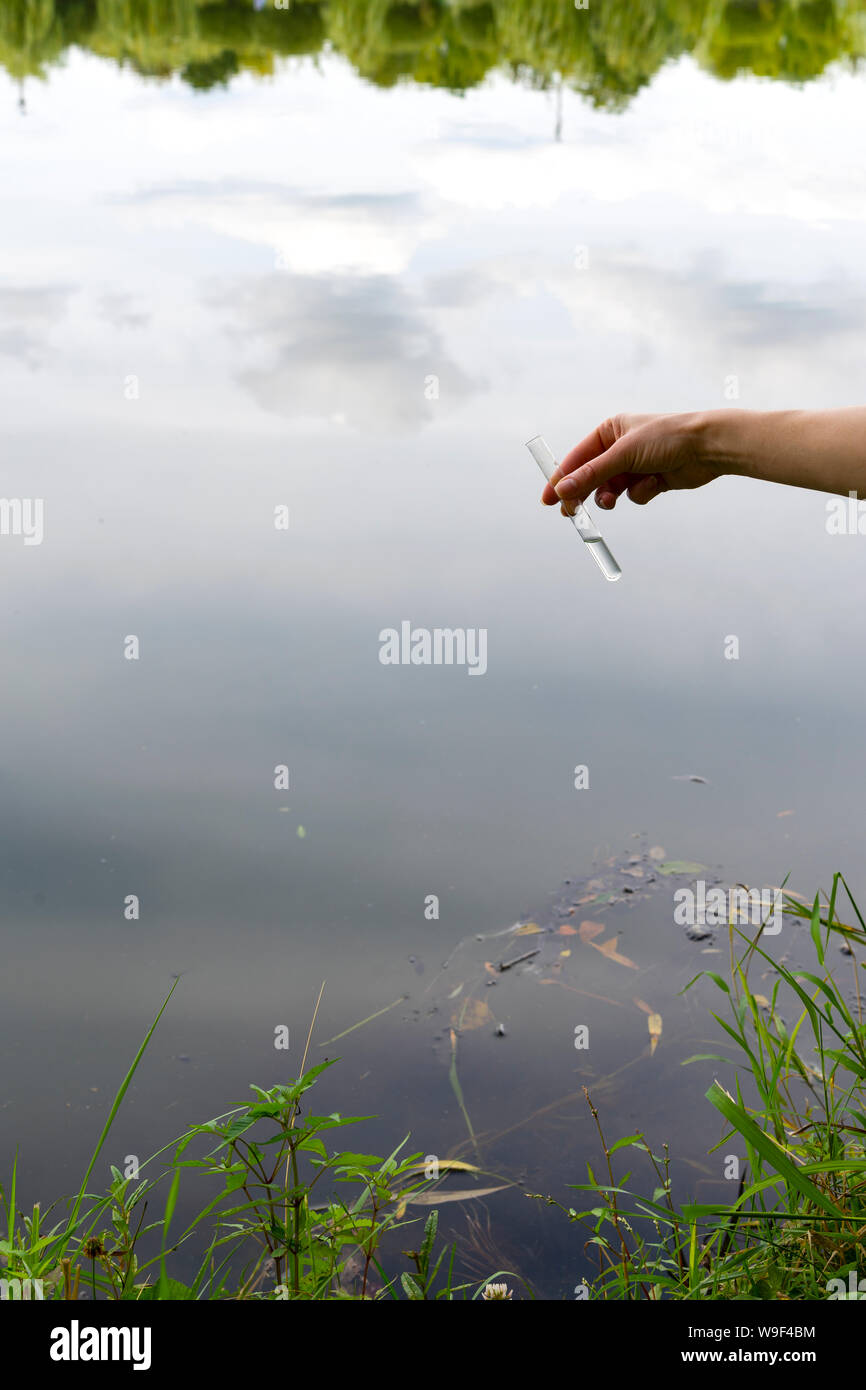 Water sample. Hand holding water in a test tube. The concept is an ...