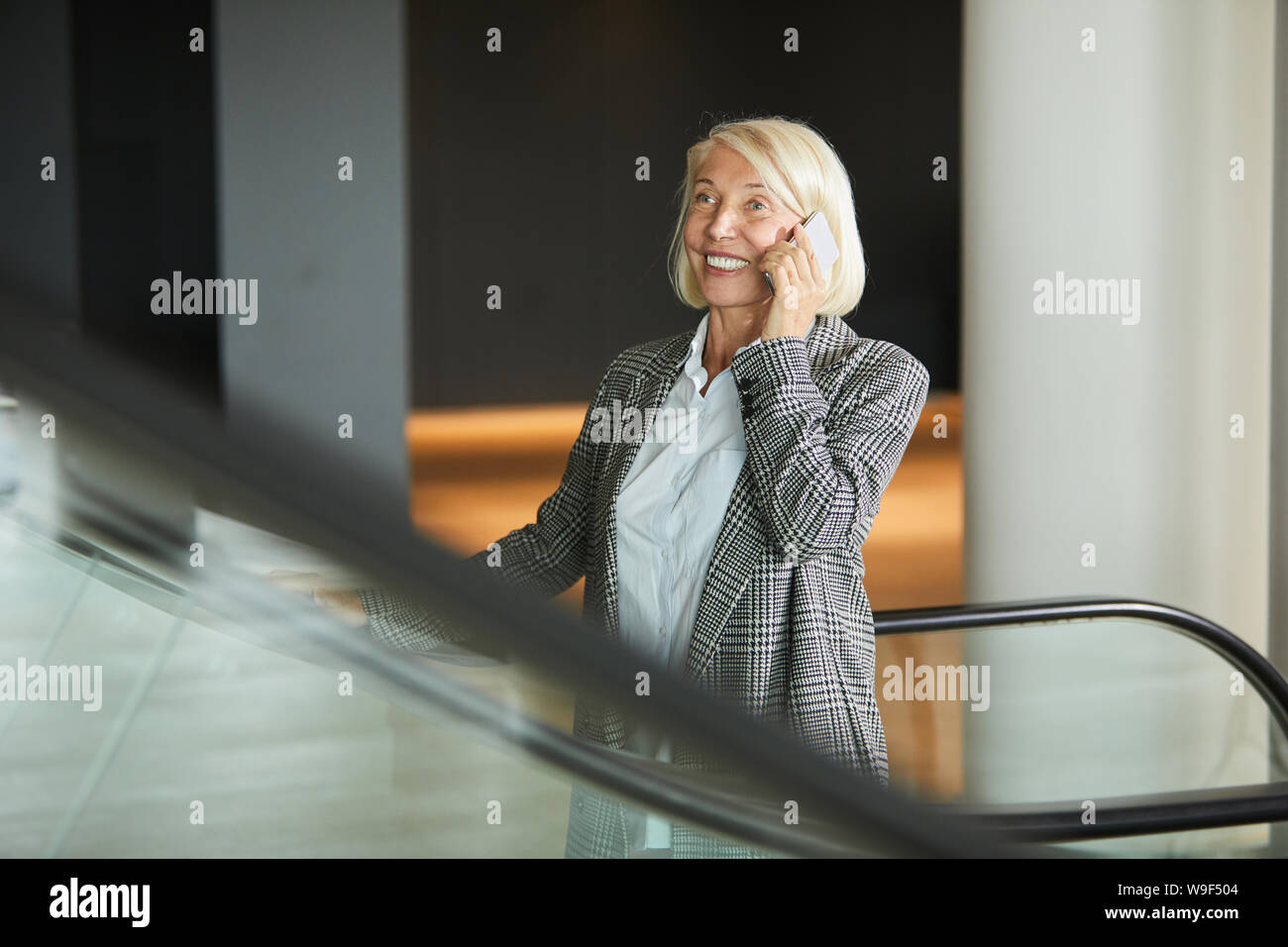 Woman moving up an escalator hi-res stock photography and images - Alamy