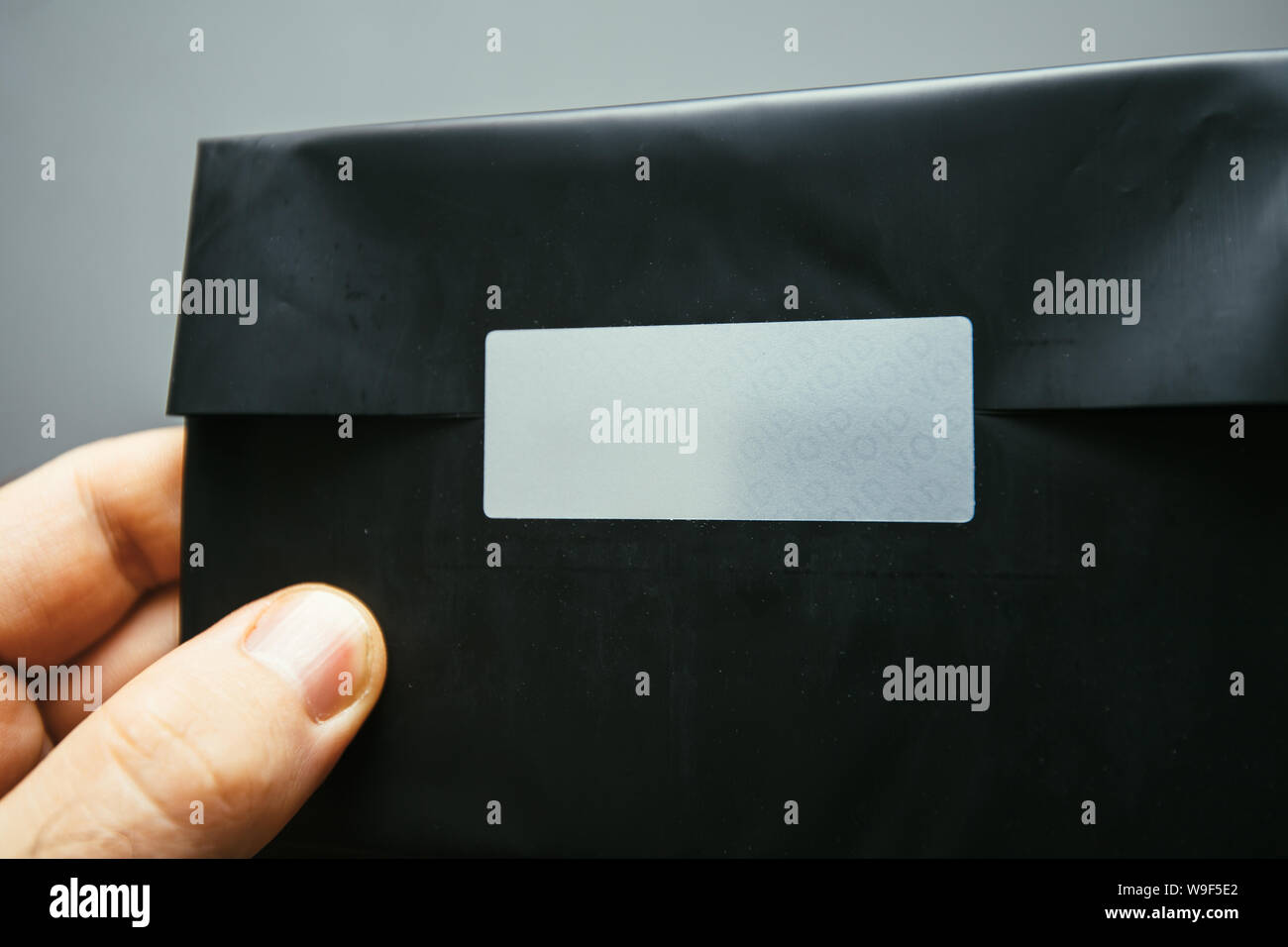 Man hand holding black plastic secret letter with VOID sticker on the ...