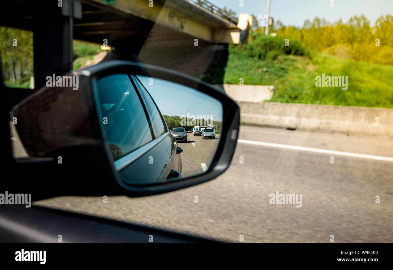 Rear view mirror of a car with multiple cars on a French highway Stock ...