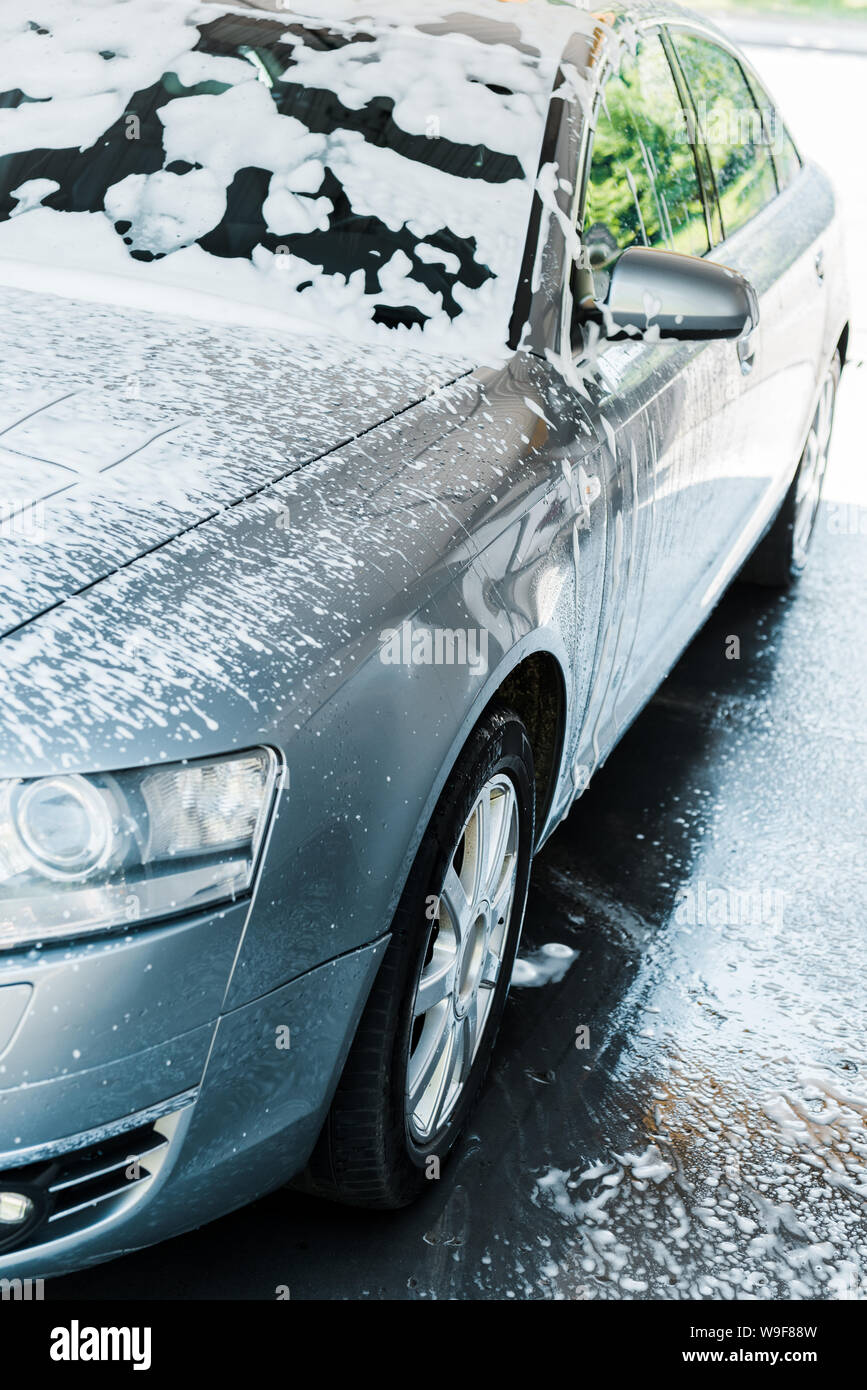selective focus of grey car with white foam in car wash Stock Photo - Alamy