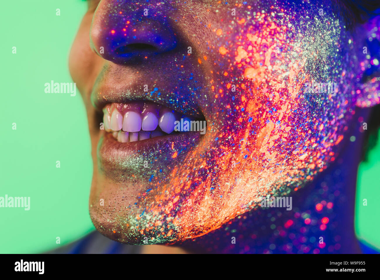 Handsome boy dancing at the rave party with fluorescent paintings on ...
