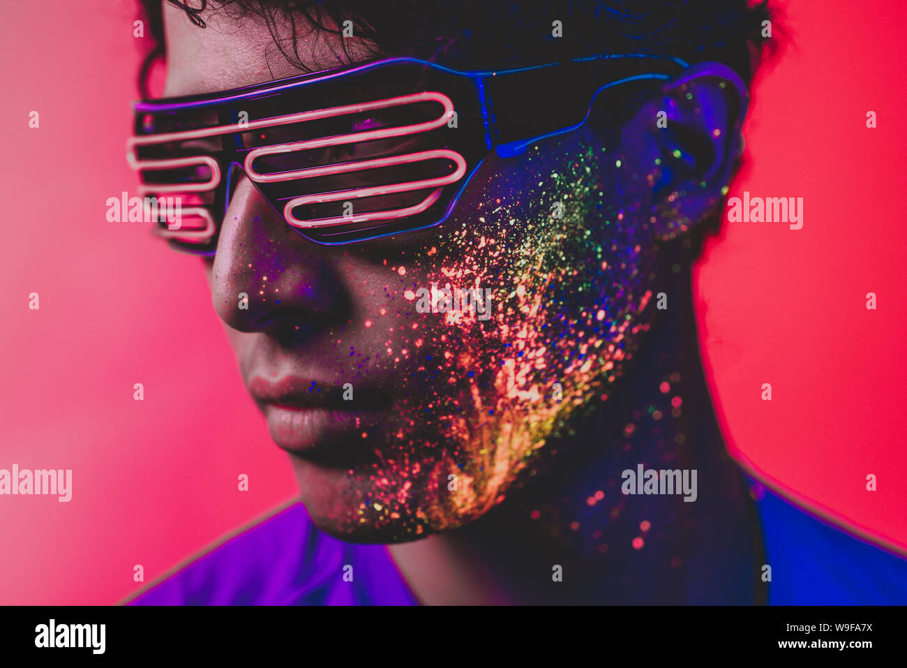 Handsome boy dancing at the rave party with fluorescent paintings on ...