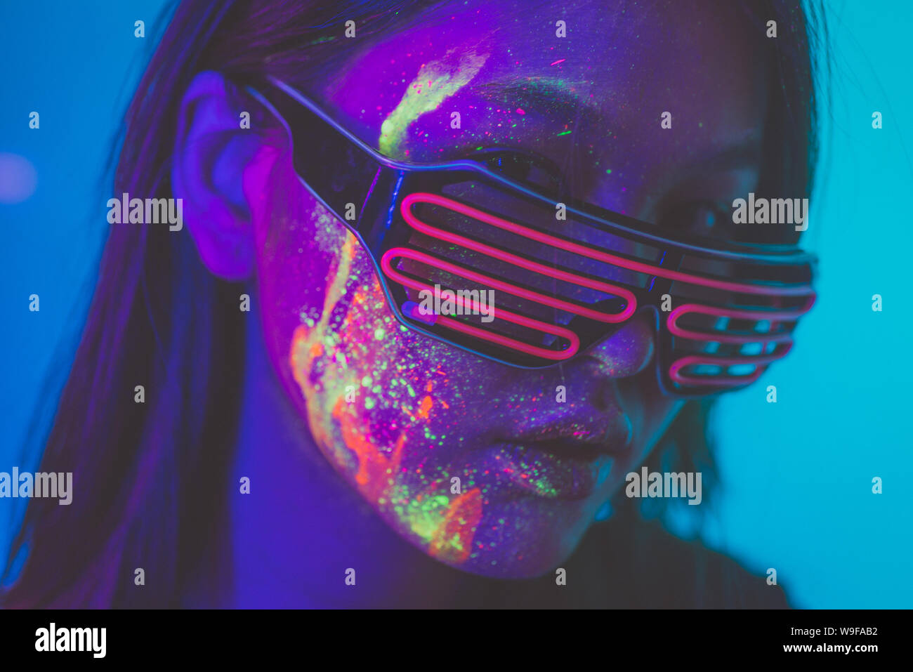 Beautiful young woman dancing and making party with fluorescent ...