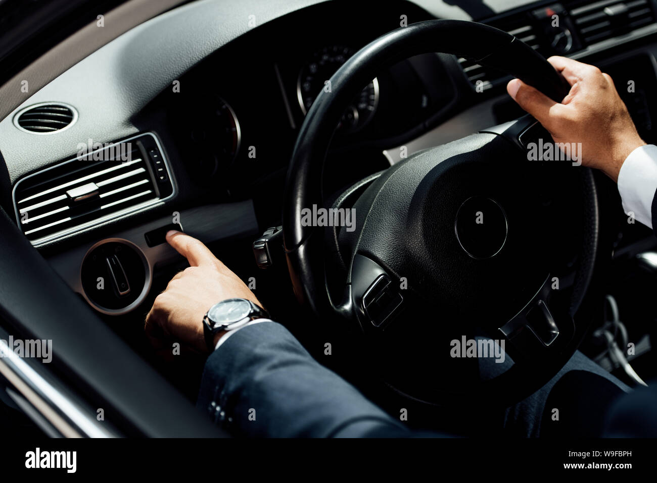 cropped view of african american businessman in suit pushing button ...