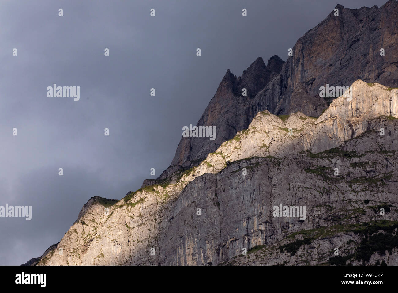 Evening sun lit sharp rocks of high mountain peak. Scenic Alpine ...