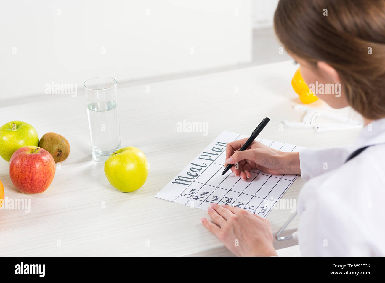 cropped view of dietitian writing meal plan at table Stock Photo - Alamy
