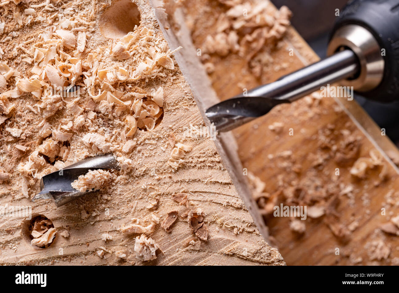 Drilling holes in raw wood. Carpentry drill in a carpentry workshop ...